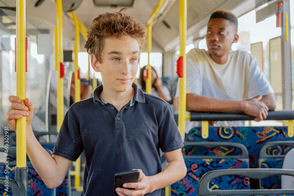 Young school-age boy is riding public transport bus to elementary ...