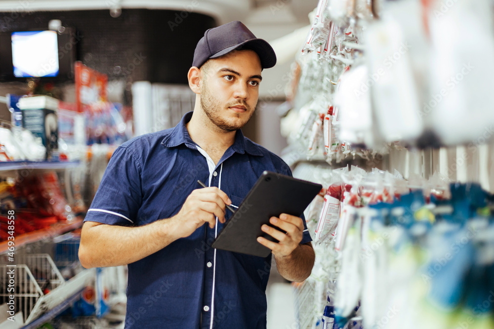 Young latin man working in hardware store Stock Photo | Adobe Stock