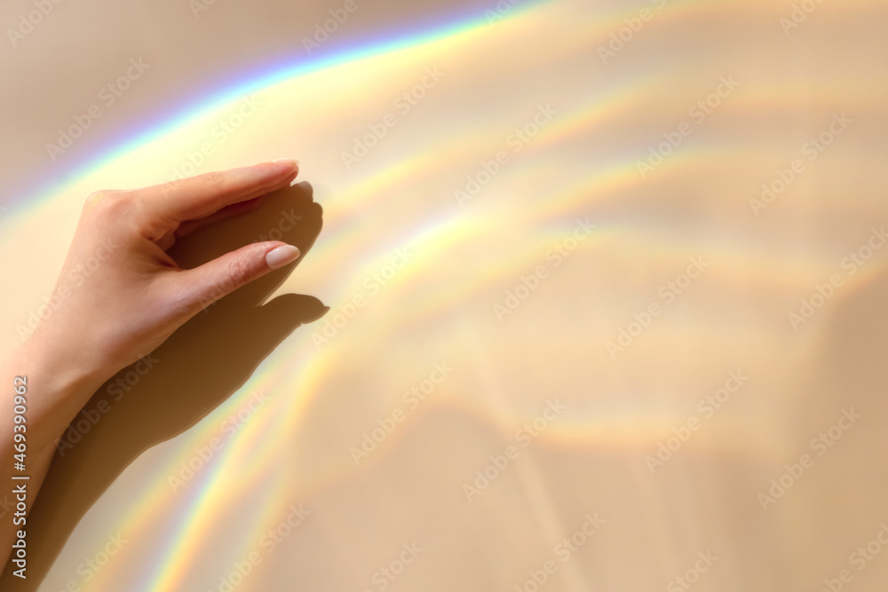 Female hand with sun refraction on beige background. Overlay mode ...