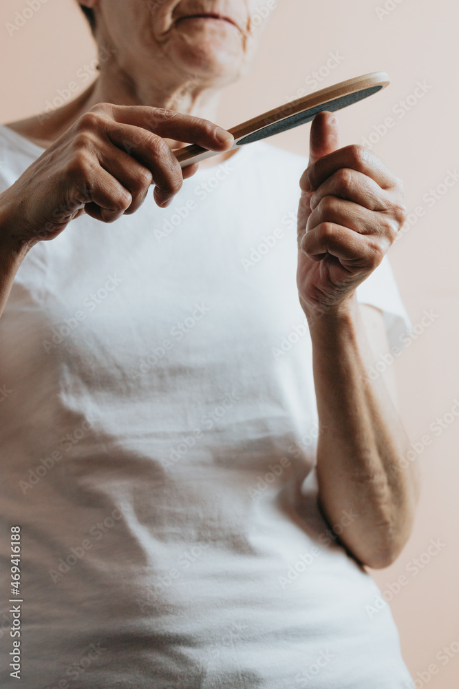 old woman filing her nails, removable flesh colored background.Elderly ...