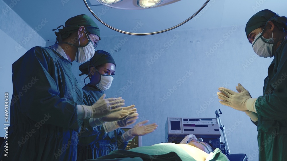 Group of surgery doctors in sterile gloves and protective face masks ...