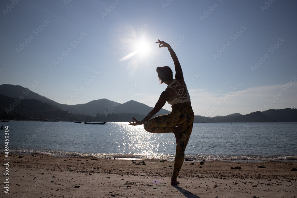 Bending Tree Pose. Asian woman doing yoga poses on a beach in Koh Pha ...