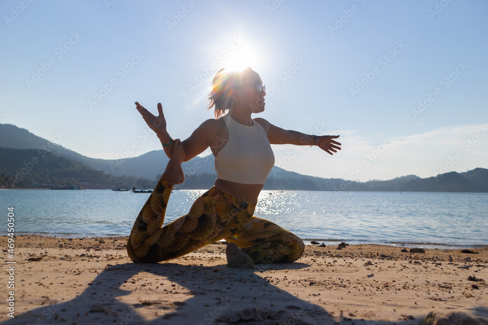Mermaid pose. Asian woman doing yoga poses on a beach in Koh Pha Ngan ...