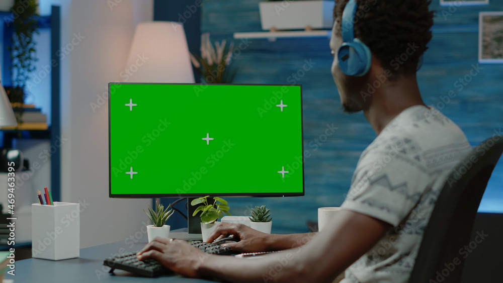 Adult looking at horizontal green screen on computer for work. Employee ...