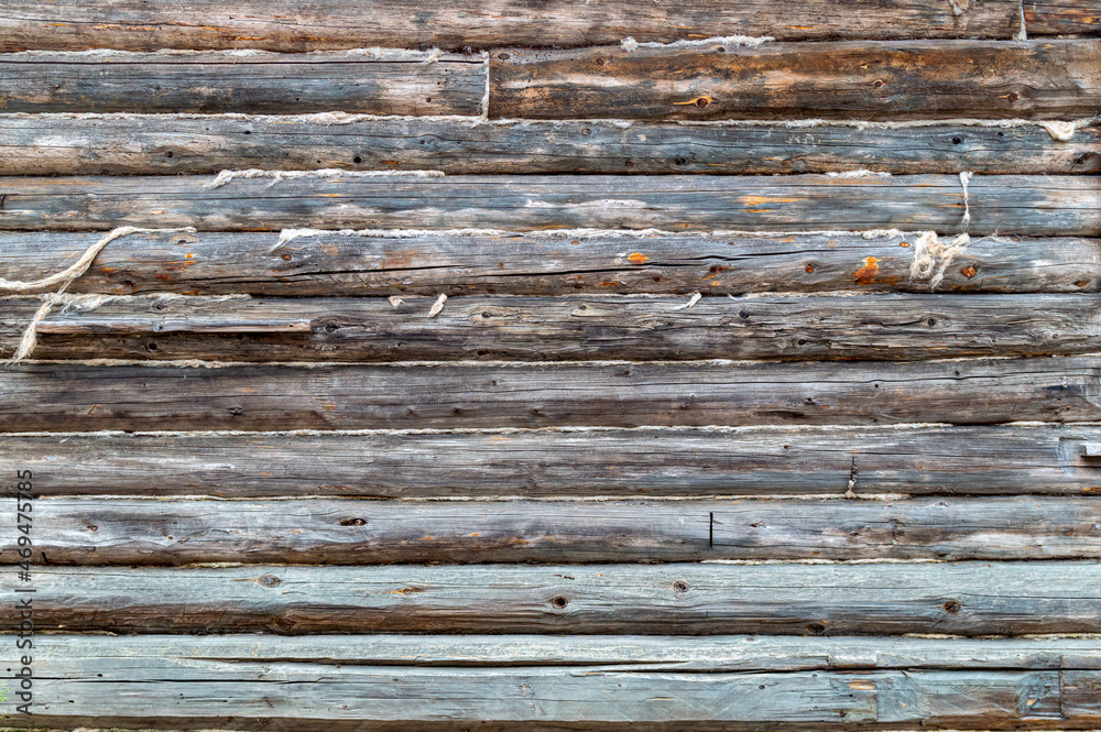 Texture of the wall of an old log house with a protruding fiber packing ...