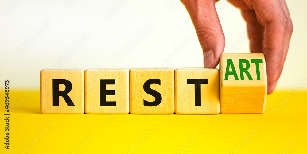 Rest and restart symbol. Businessman turns a wooden cube and changes ...