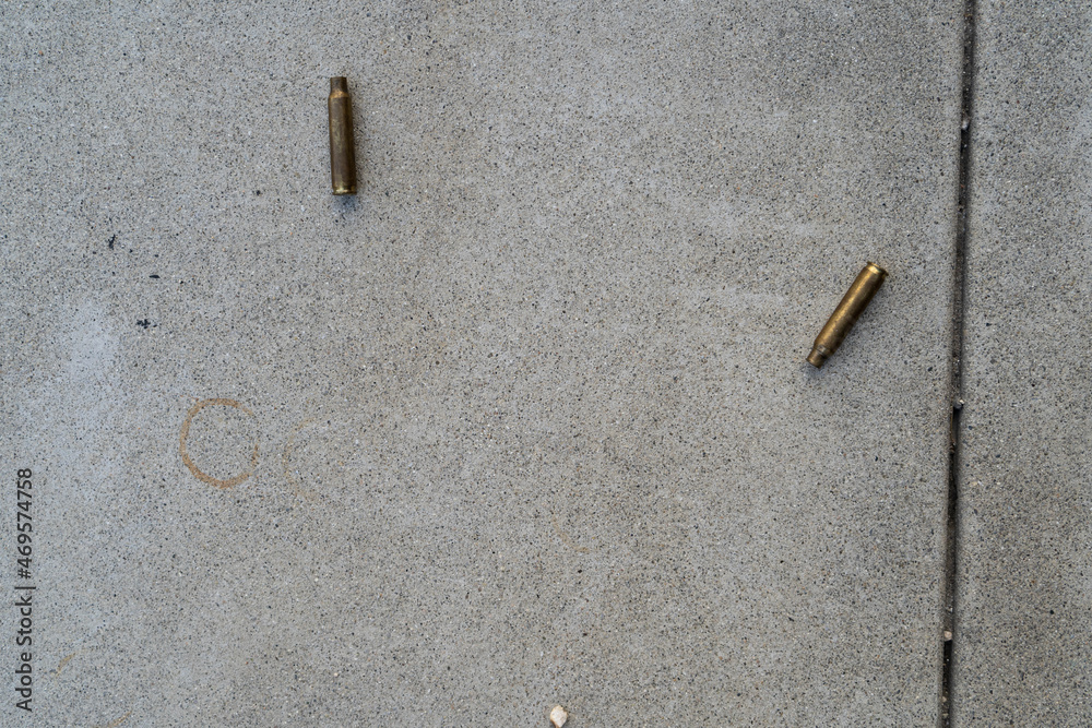 Different caliber bullet shell casings on concrete sidewalk pavement ...