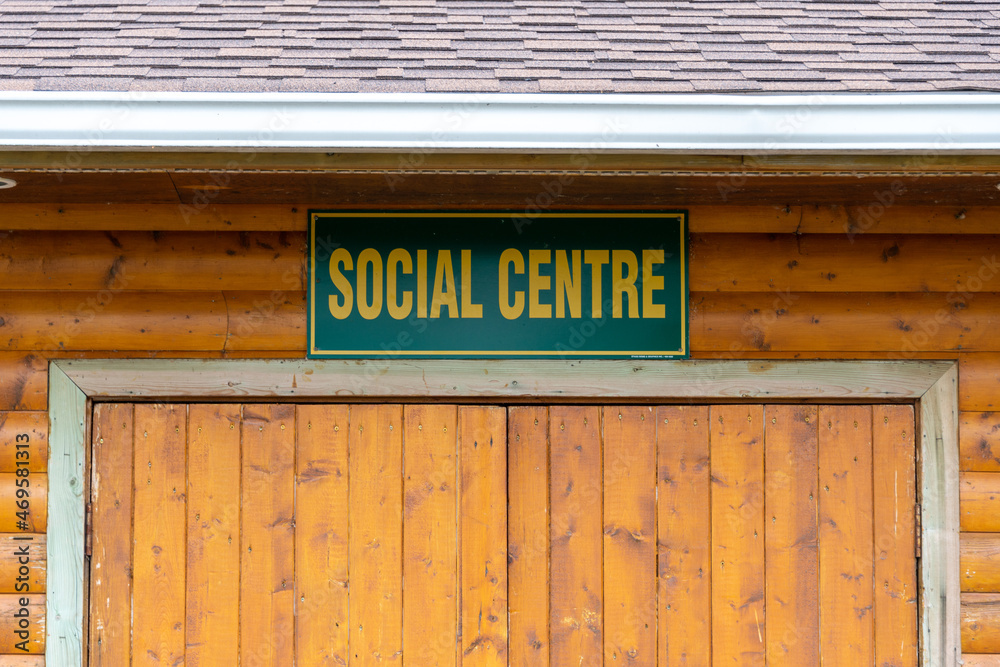 A building with orange log siding and a sign with the words social ...