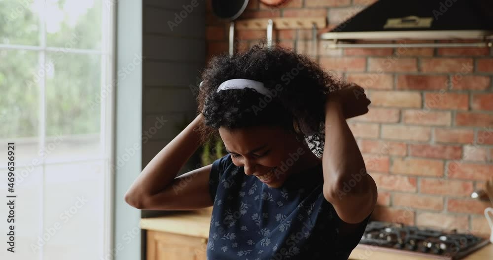 Close up African woman distracted from cooking in kitchen listening ...