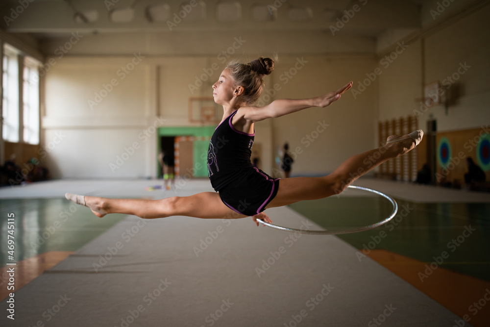 Girl gymnast jumping the splits with silver hoop in gym Stock-Foto ...