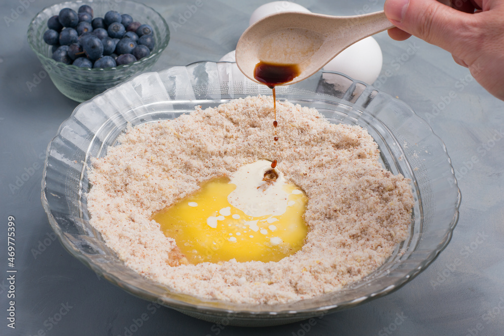 Person adding syrup into bowl with ingredients for muffins Stock Photo ...