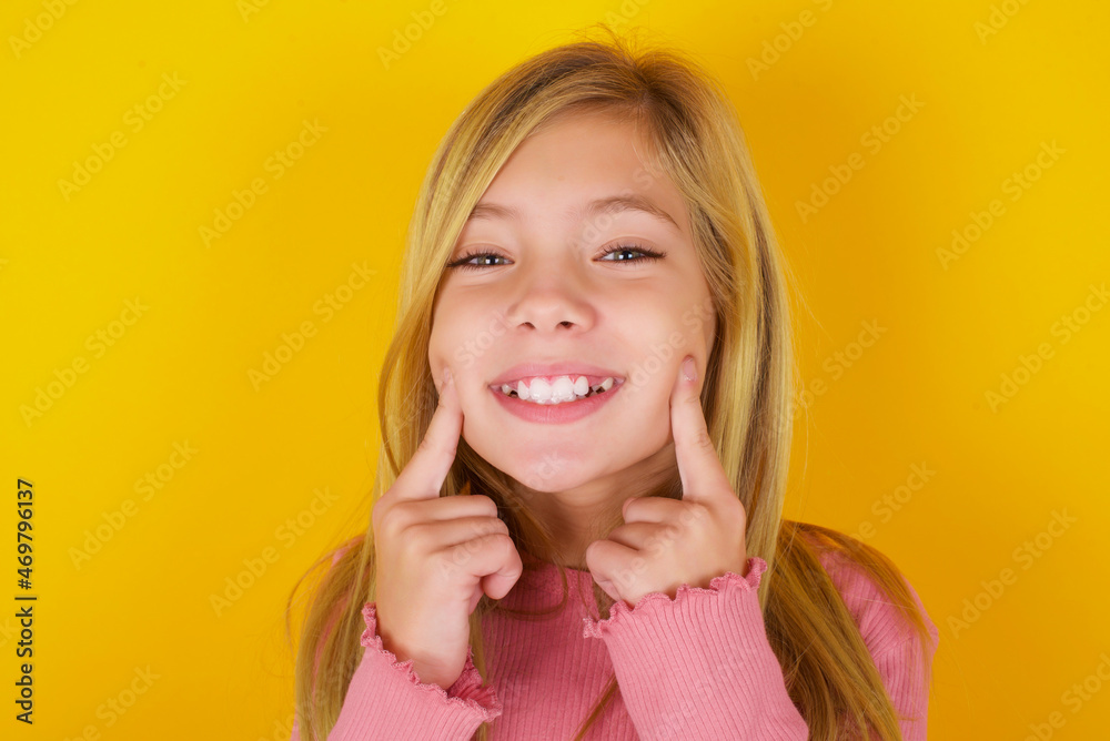 Happy caucasian little kid girl wearing long sleeve shirt over yellow ...