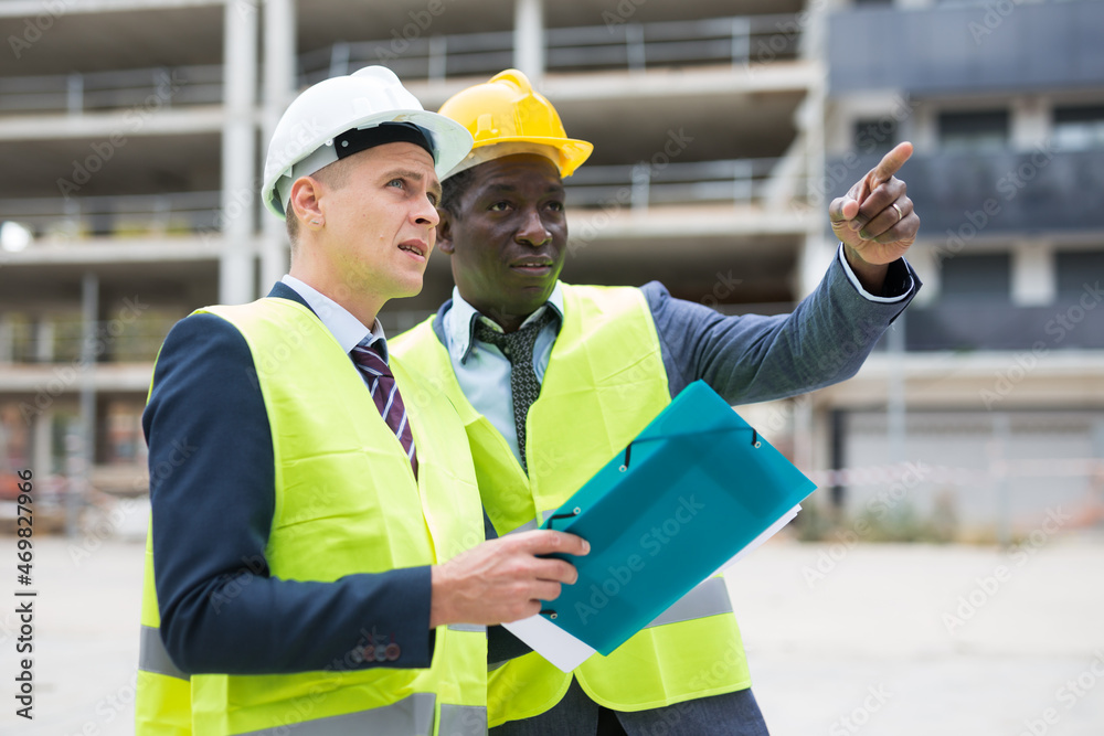 African-american civil engineer discussing a construction plan with a ...