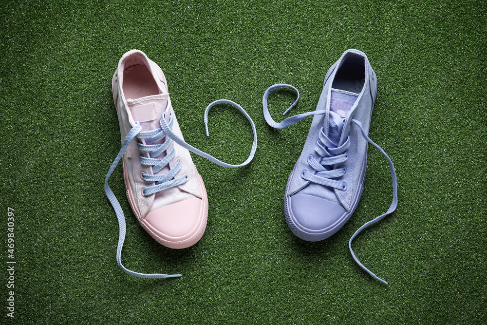 Different shoes with untied laces on color background Stock Photo ...