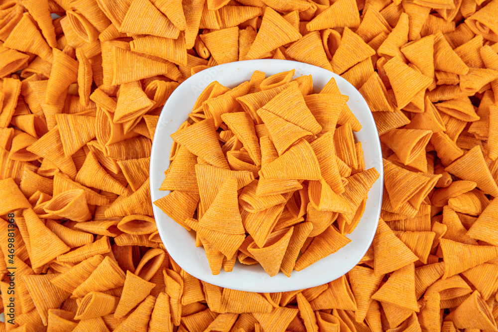 Portion of cone shaped snack tornado shaped crackers. Yellow spicy ...