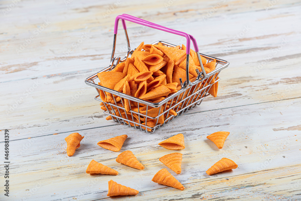 Portion of cone shaped snack tornado shaped crackers. Yellow spicy potato cone chips texture or ...