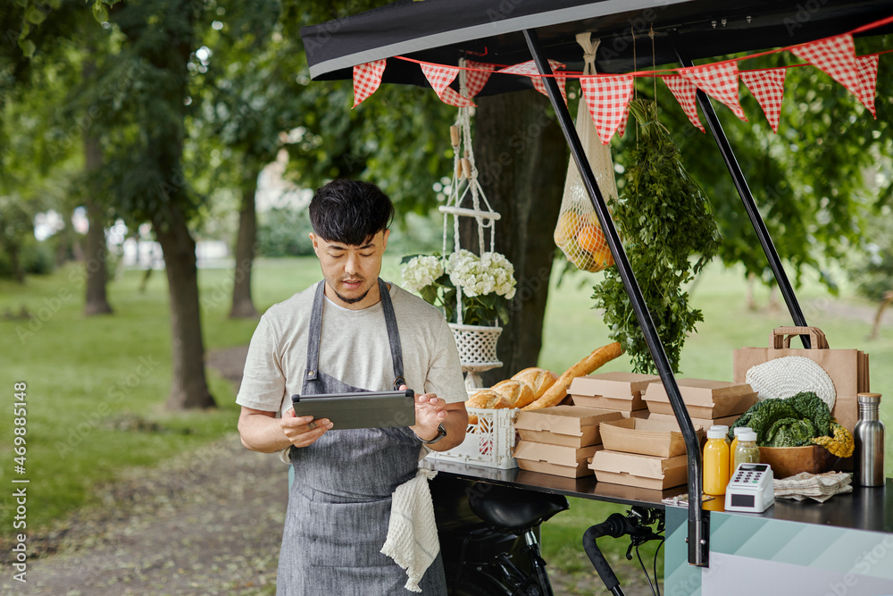Man standing in front of food stall Stock Photo | Adobe Stock