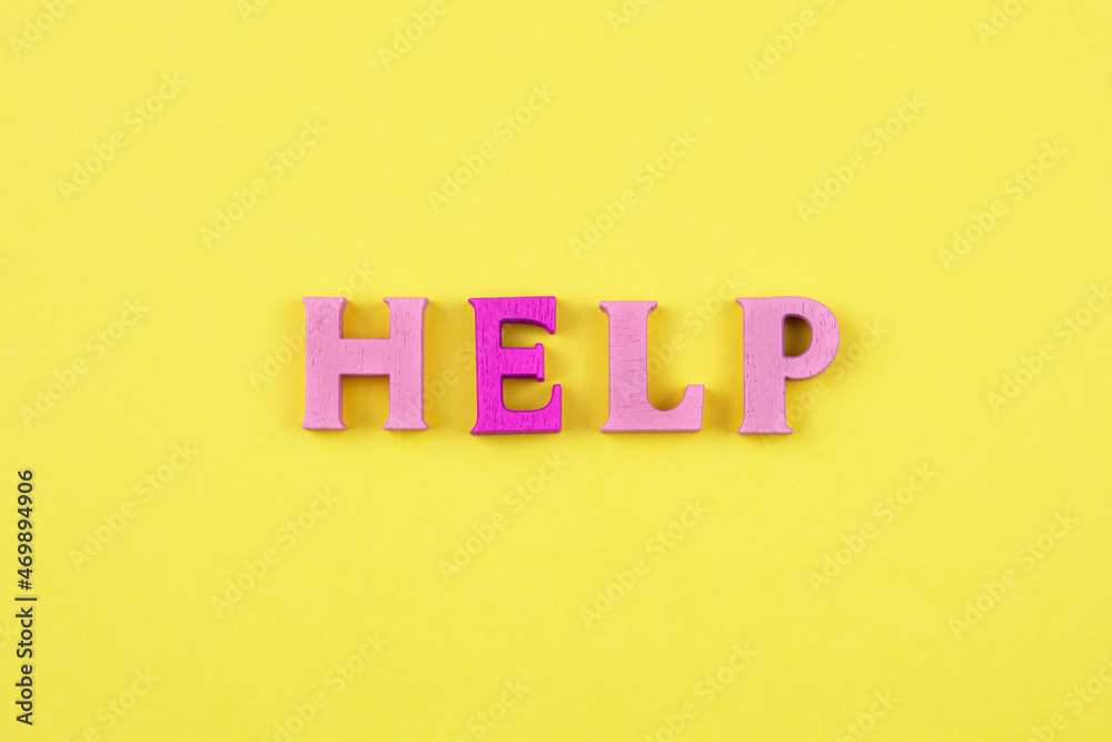 The word help from wooden bright letters on a yellow background. The ...
