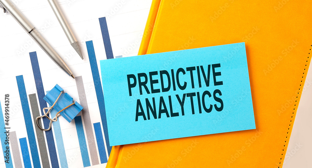 PREDICTIVE ANALYTICS text on sticker on the yellow notebook with chart ...