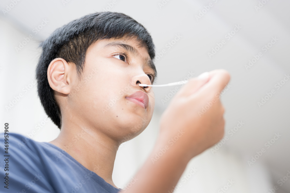 Foto de Asian boy self collecting nose swab for corona virus sample ...