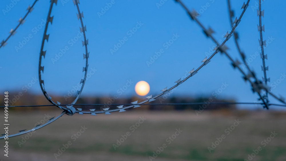 Barbed wire over abstract full moon sky background. Border with barbed ...