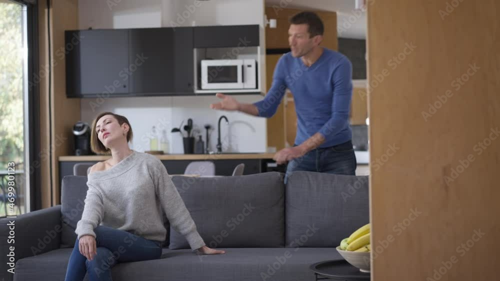 Slim woman sitting on couch standing up walking away as aggressive ...