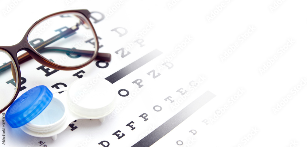 Contact lenses case and eye glasses on and eye test chart. Vision ...