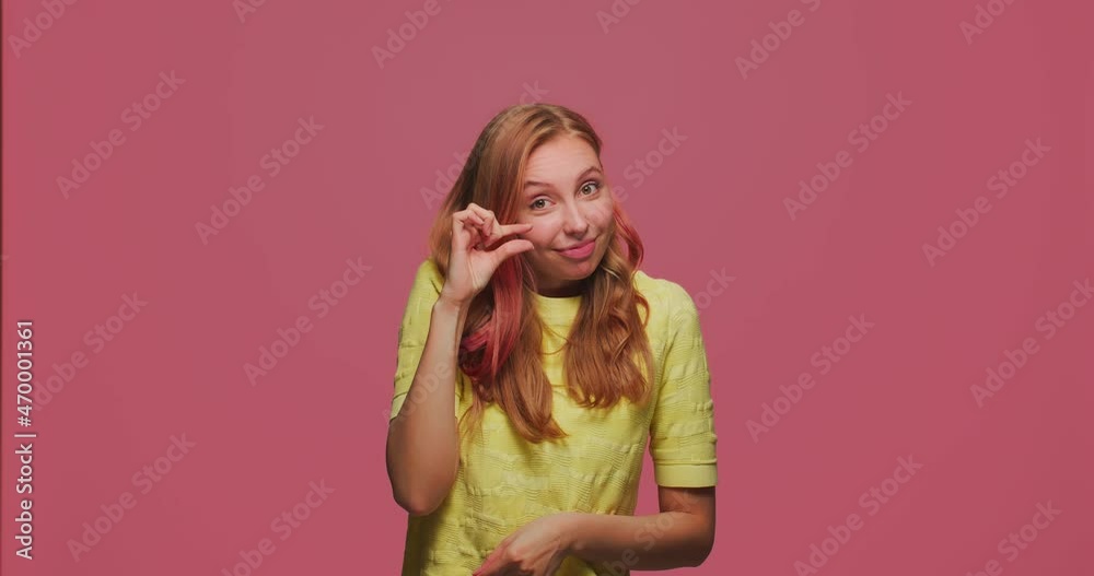 Little bit gesture. Funny happy young girl showing small size by ...