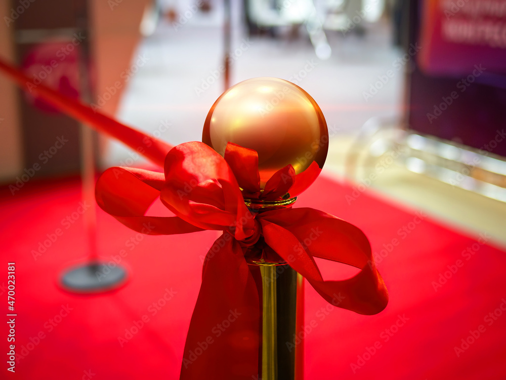 Opening ceremony of an event. A red festive satin ribbon tied to a gold ...