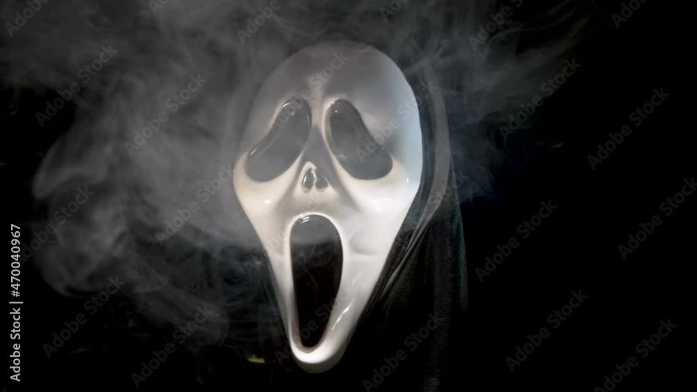 The white smoke coming out of the halloween mask inside the dark room ...