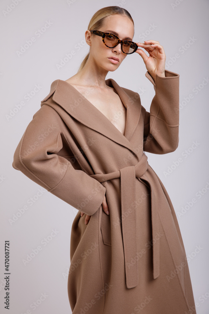High fashion photo of a beautiful elegant young woman in a pretty beige ...