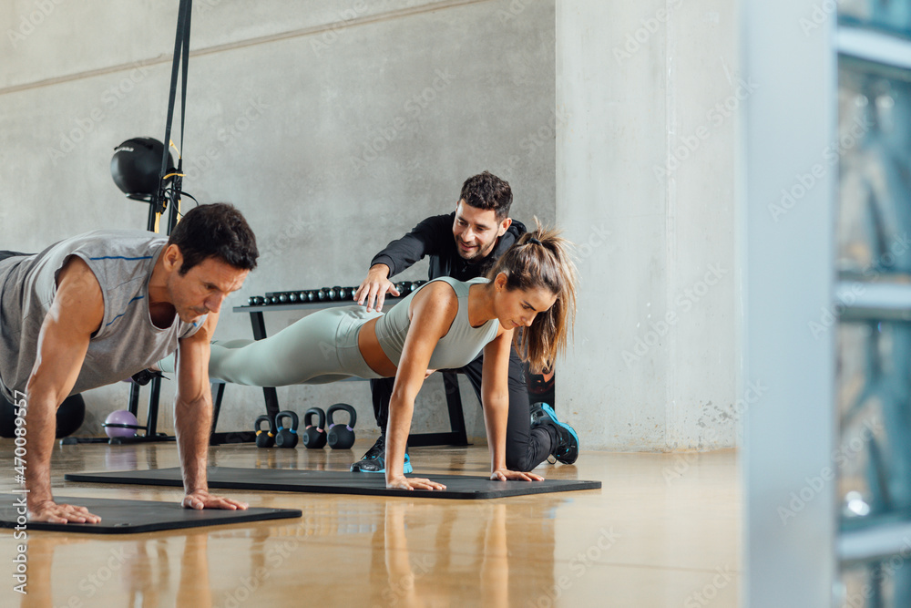 Personal trainer assist a woman during a fitness class. Stock Photo ...
