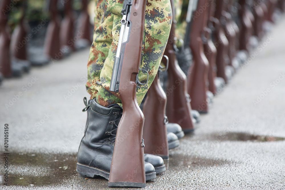 Soldiers in boots and a rifle.Soldiers stand in row. Gun in hand. Army ...