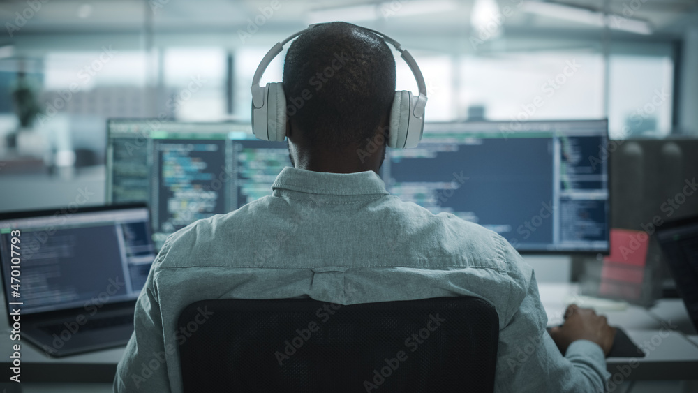 Office: Professional Black IT Programmer Uses Headphones while Working ...