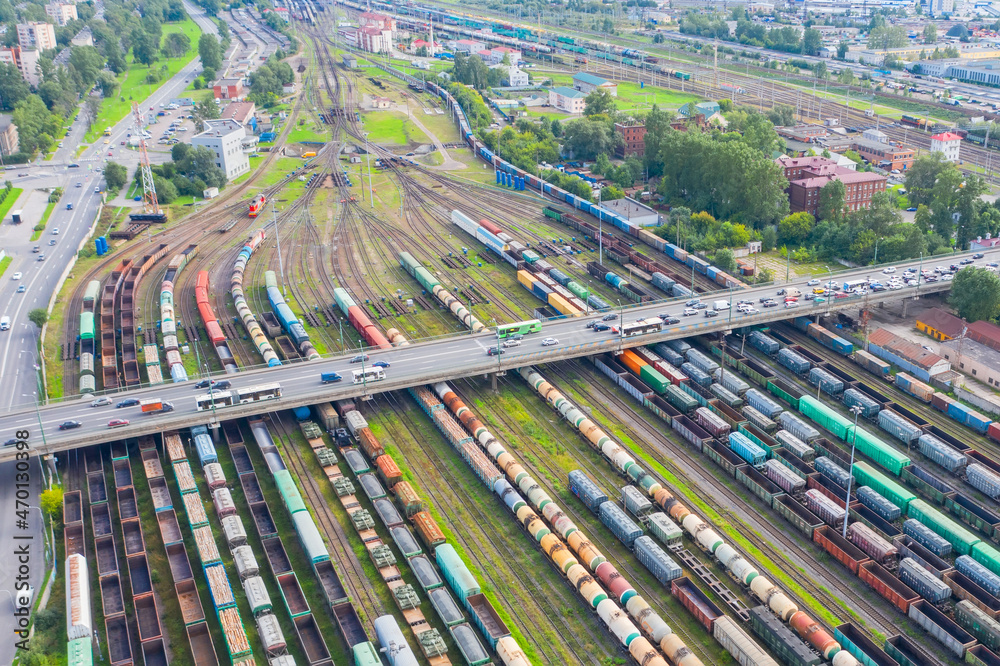 Railway marshalling yard and road bridge above it with cars. Import and ...