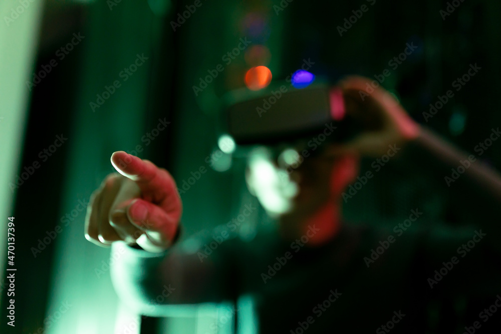 Asian man wearing vr headset touching an invisible screen in computer ...