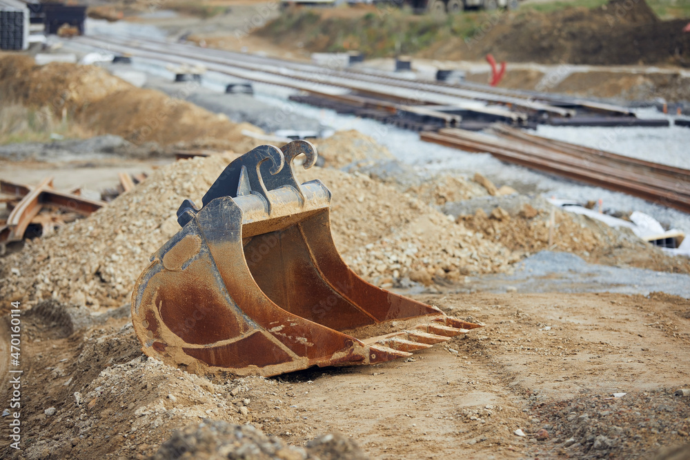 Building of railroad track. Excavator bucket on construction site of ...