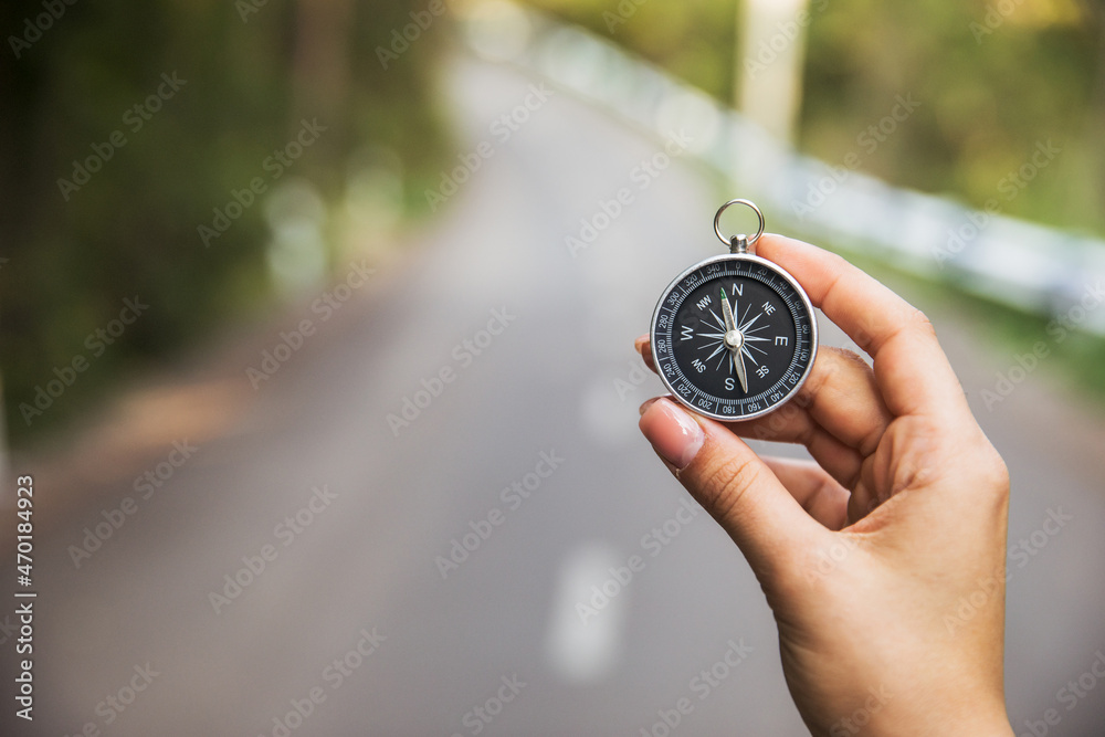 woman holding compass in road background Stock Photo | Adobe Stock