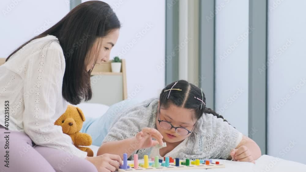 Girl with down syndrome is practicing fun playing with toys at home ...