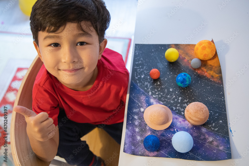 Happy preschooler made a solar system model. Handmade models of planets ...