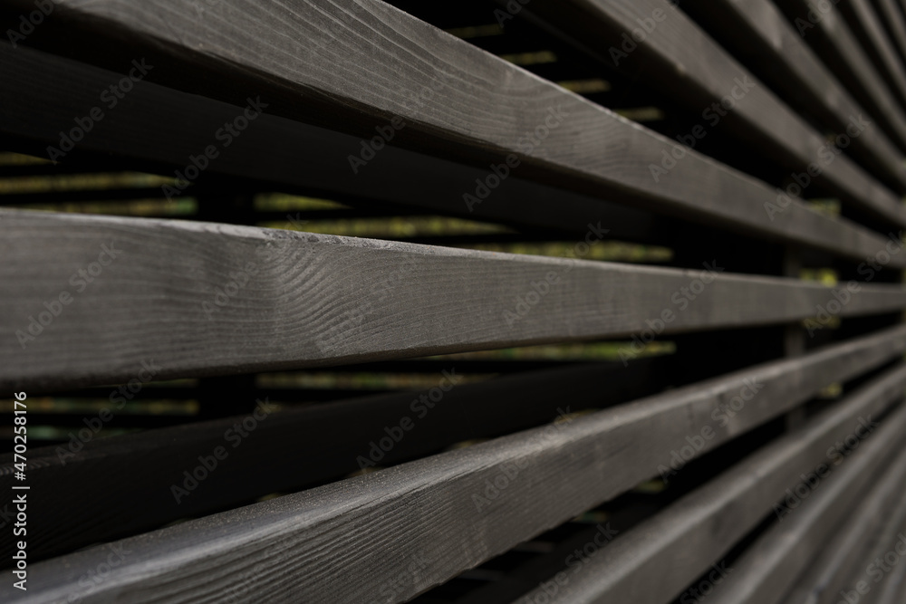 Side view of a wall of black horizontal wooden bars. The beauty of ...