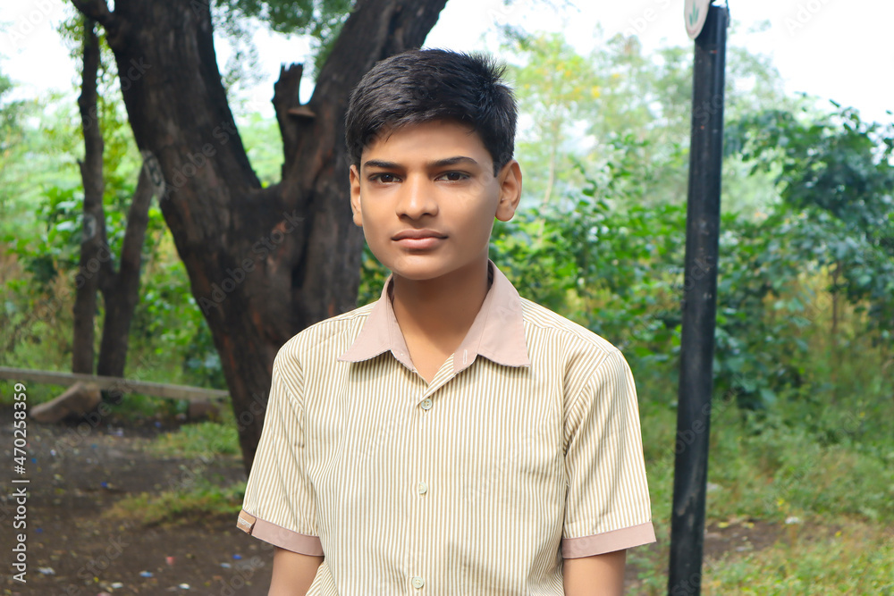 Indian school boy standing over nature background. Stock Photo | Adobe ...