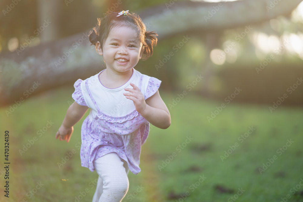 Happy baby girl smiling. little girl running at sunsetHappy baby girl ...