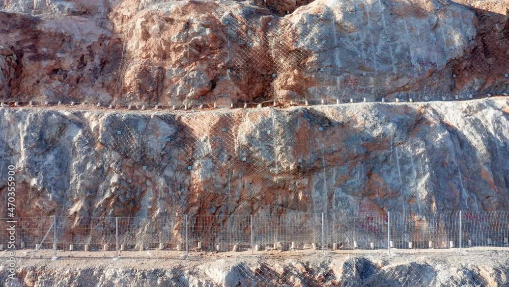 Terraces on a steep slope with protective mesh netting are safety ...