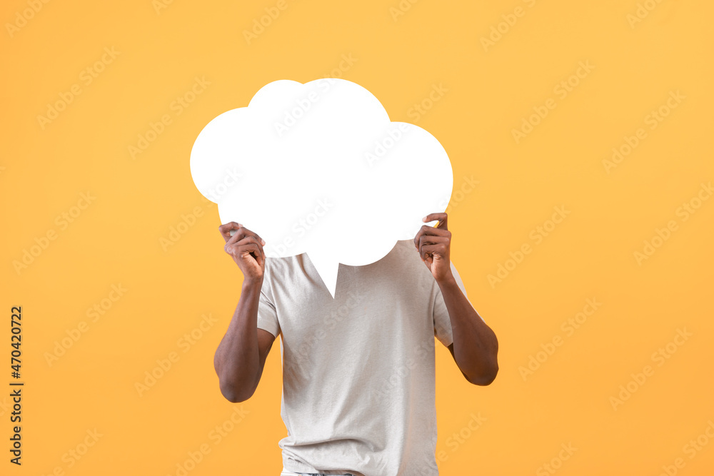 Faceless african american man covering his face with white speech ...