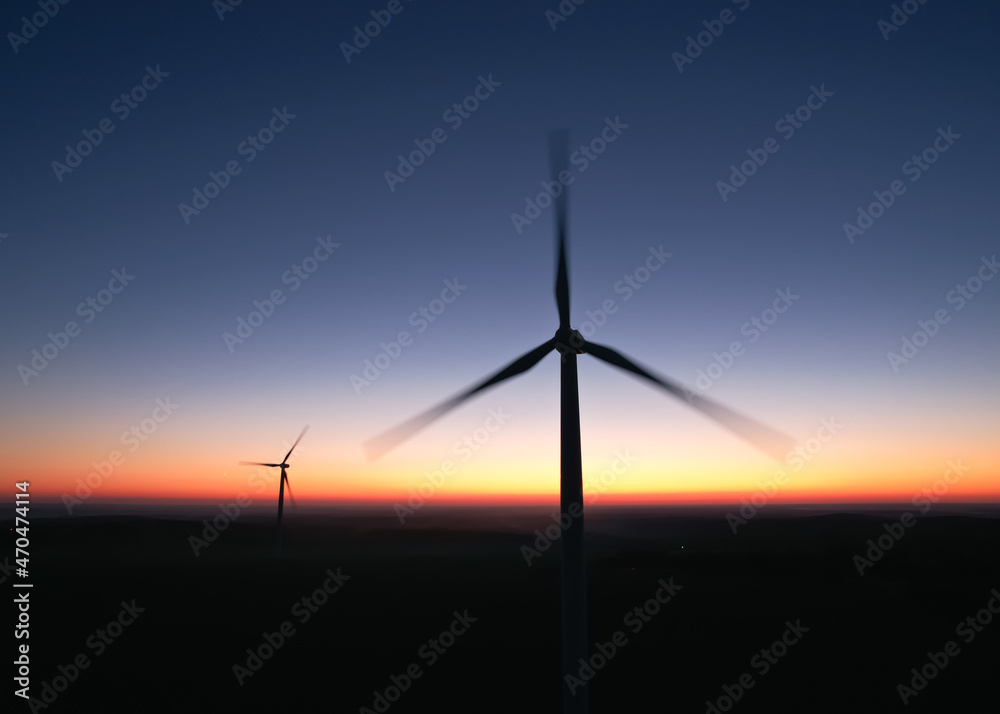 AERIAL VIEW: two rotating silhouettes of wind turbine propellers ...