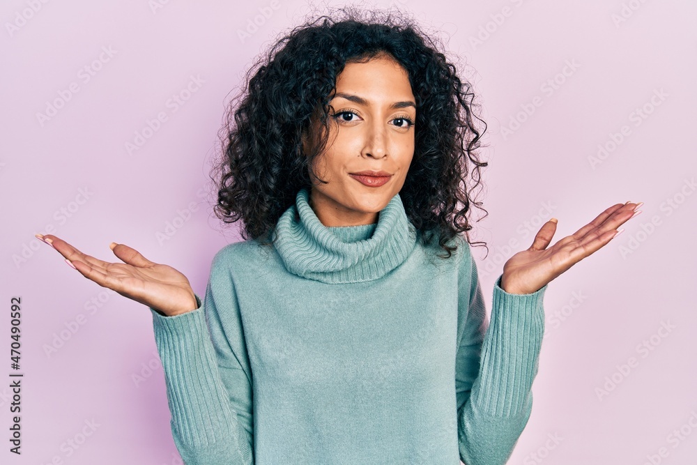 Young latin girl wearing casual clothes clueless and confused with open ...