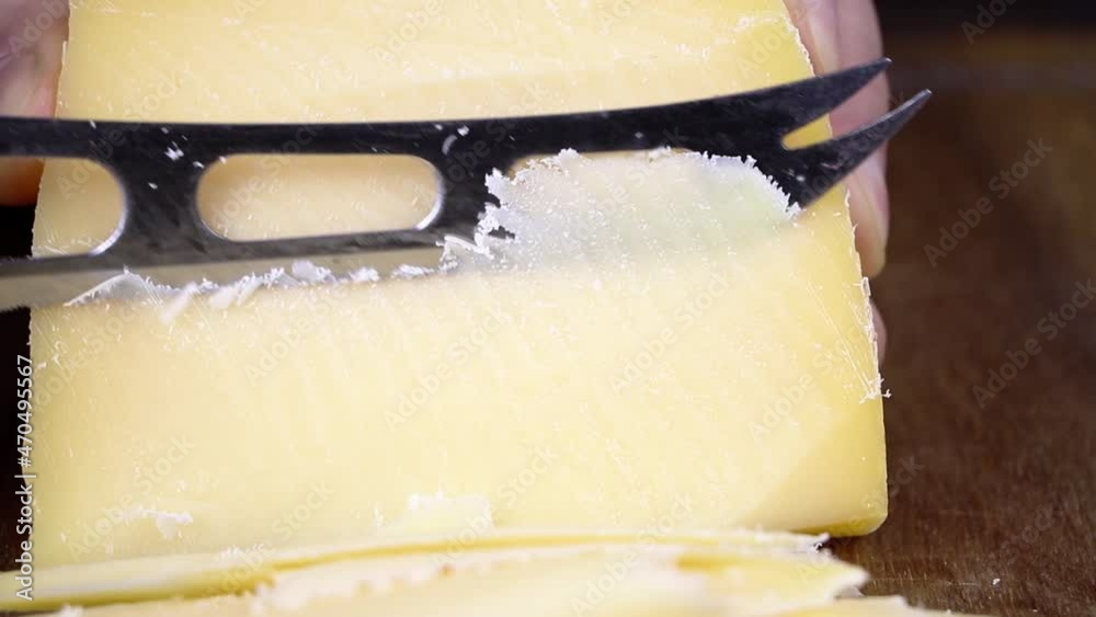 Slicing cheese. A man cuts cheese on a cutting board.Hard cheese ...