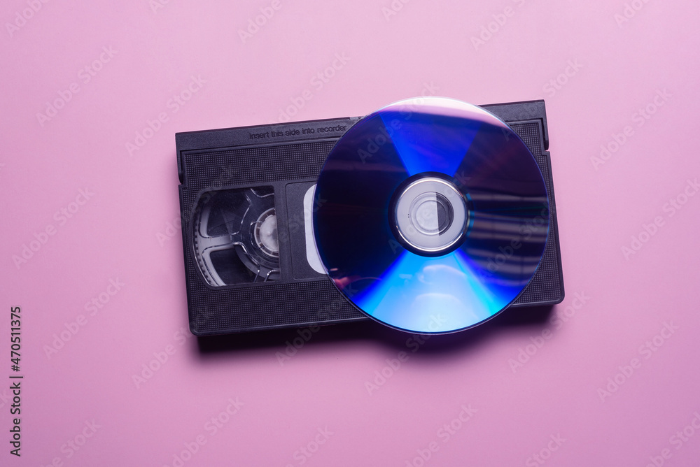 VHS cassette and CD compact disk on the purple background top view ...