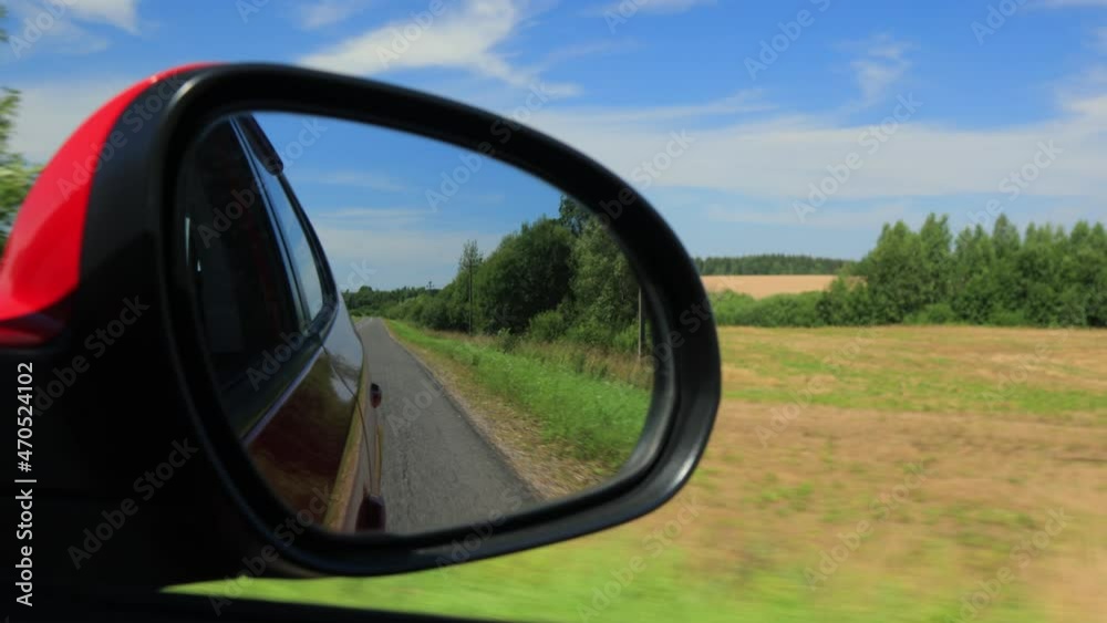 Red automobile in motion. View in the rear view side mirror of a auto ...
